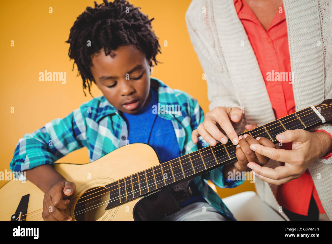 Boy learning how to play the guitar Stock Photo - Alamy