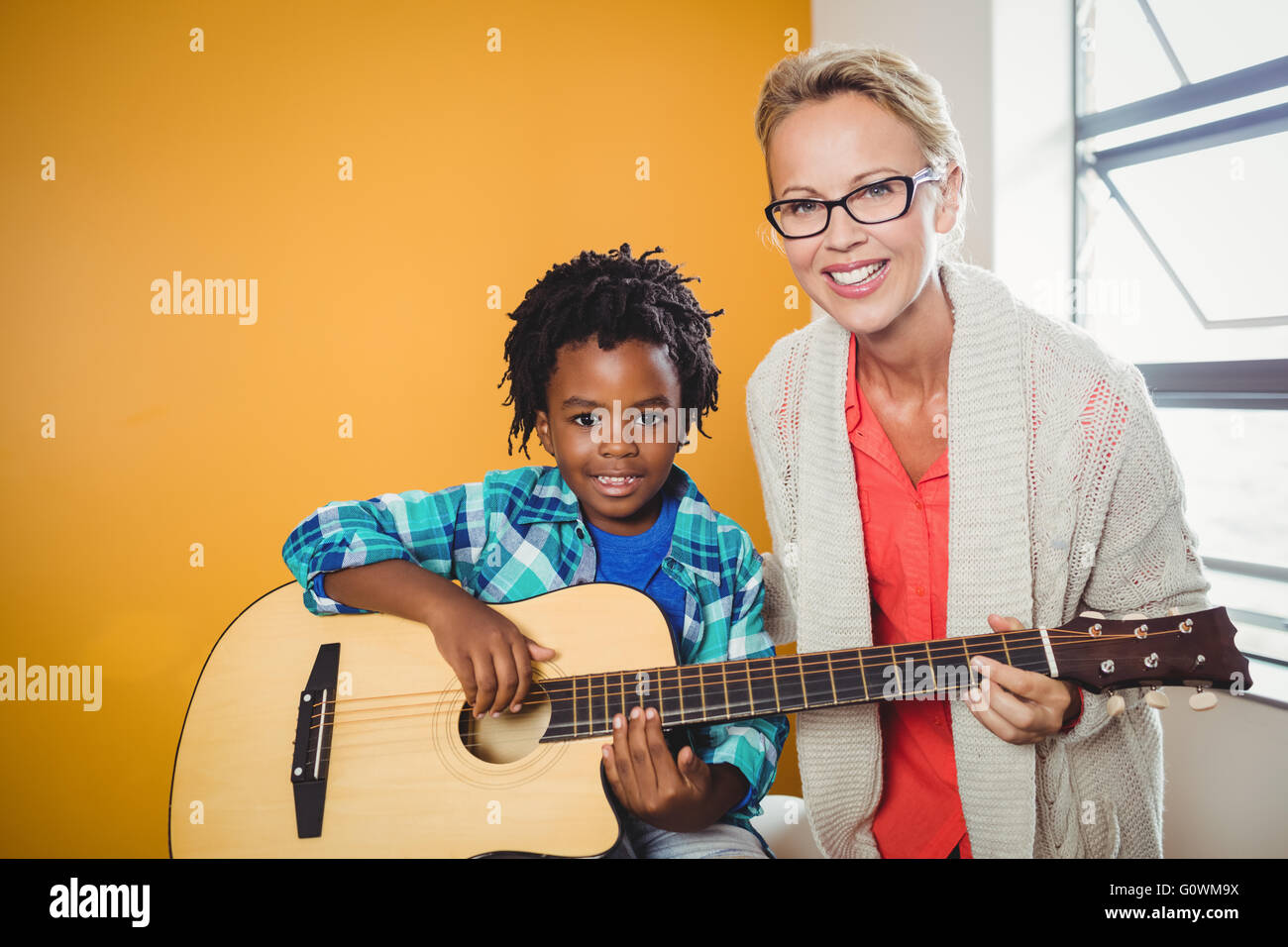 Boy learning how to play the guitar Stock Photo - Alamy