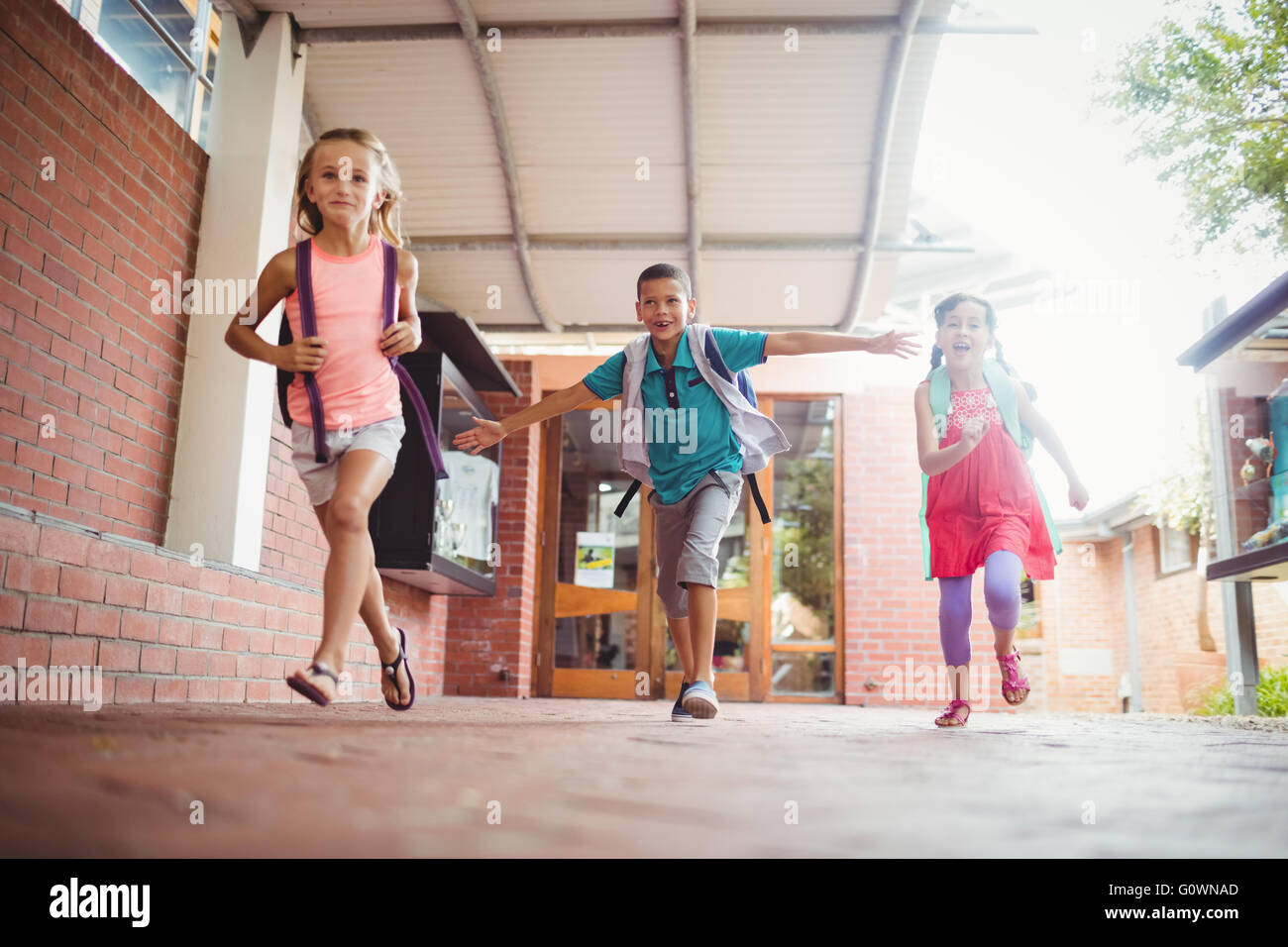 Three kids running in the playground Stock Photo - Alamy