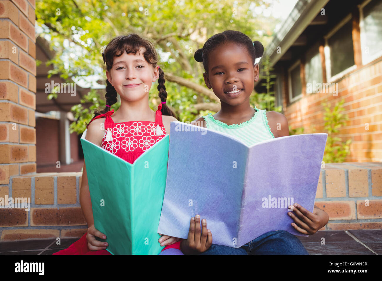 Two children holding a book Stock Photo - Alamy