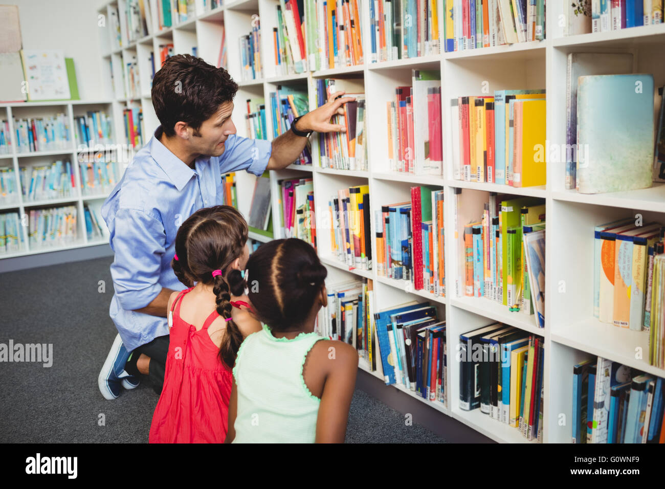Kids selecting a book Stock Photo - Alamy