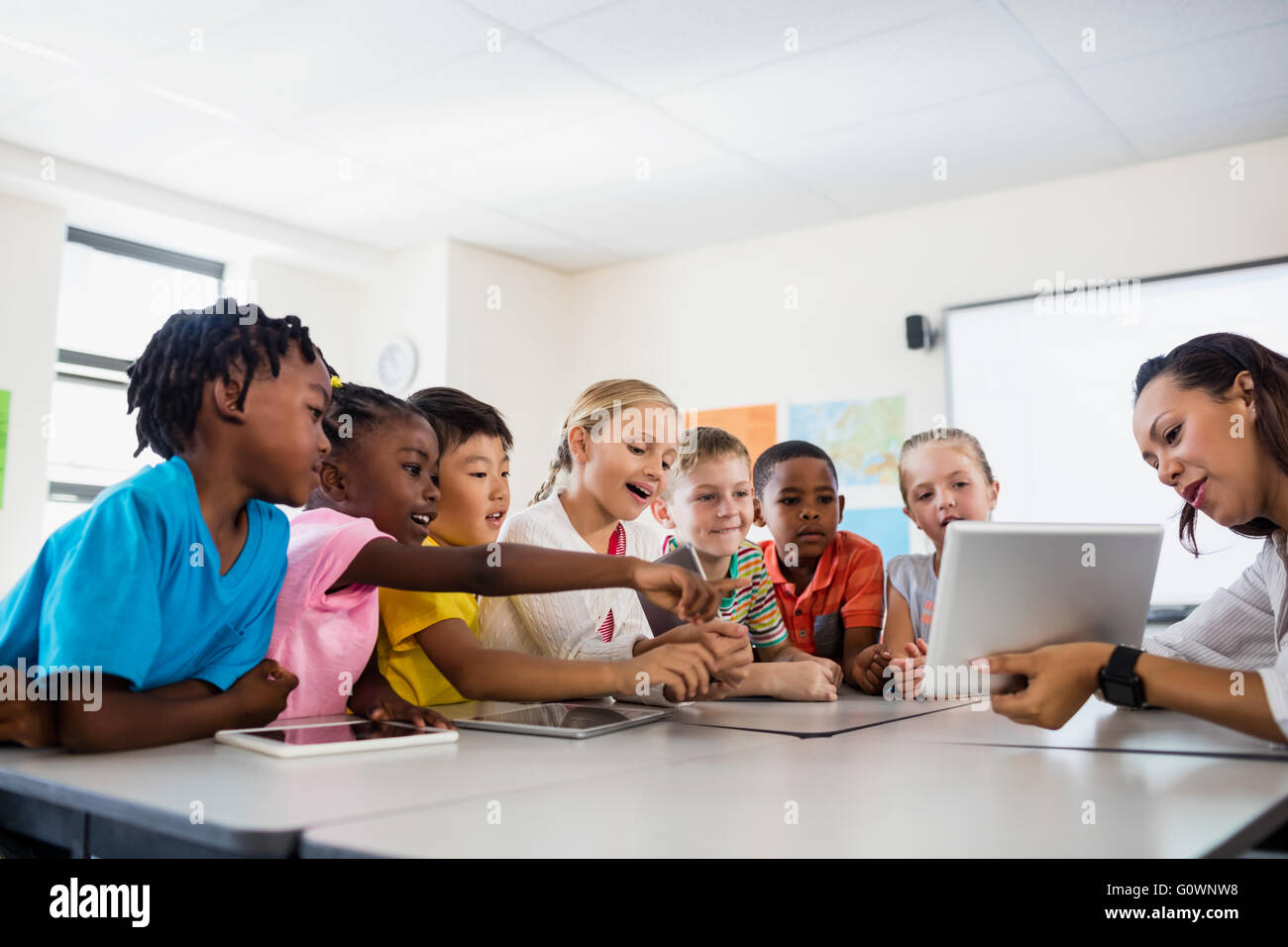 A teacher giving lesson with tablet computer Stock Photo - Alamy