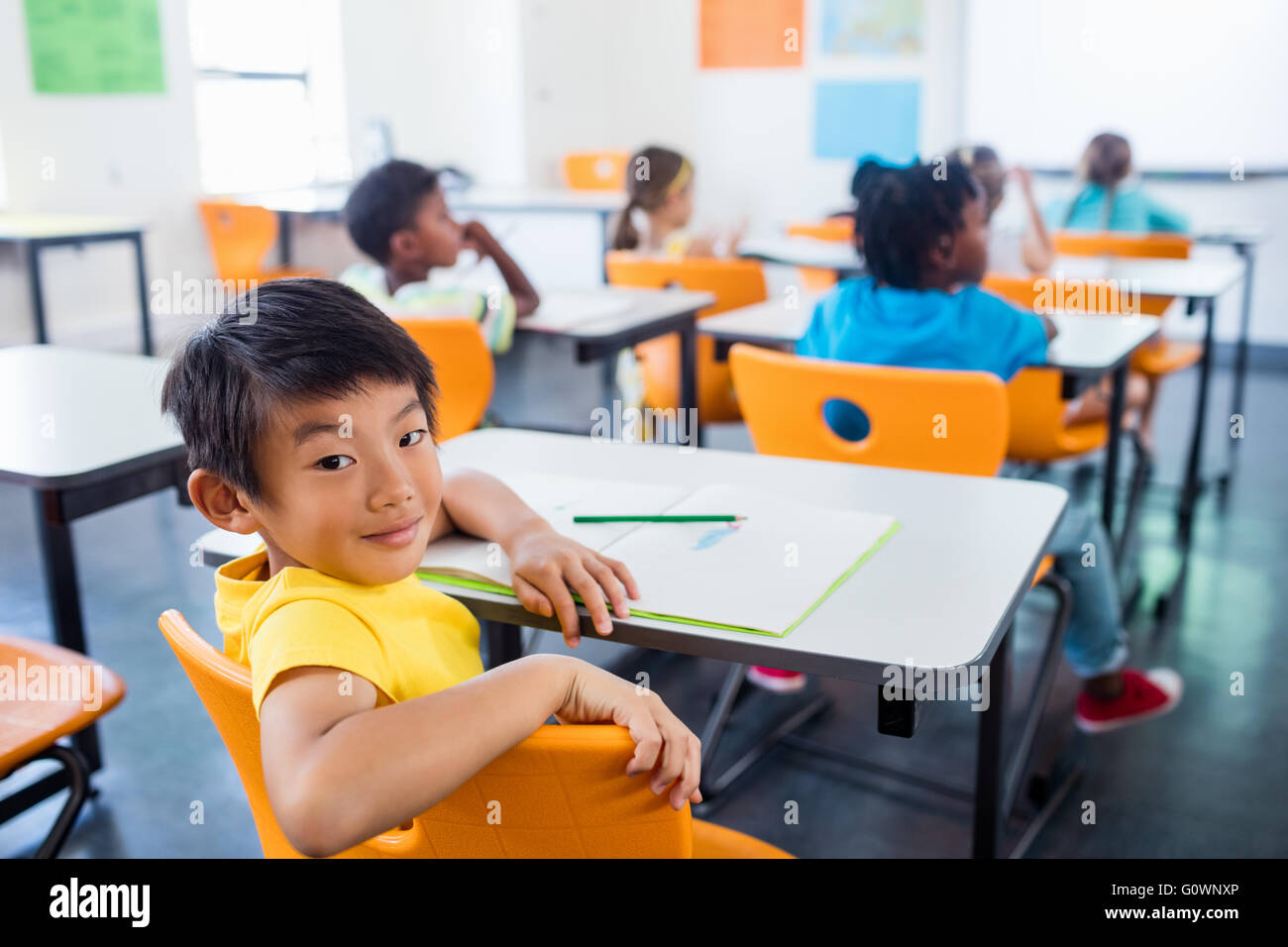 pupil sitting at his desk looking at camera in classroom Stock Photo ...