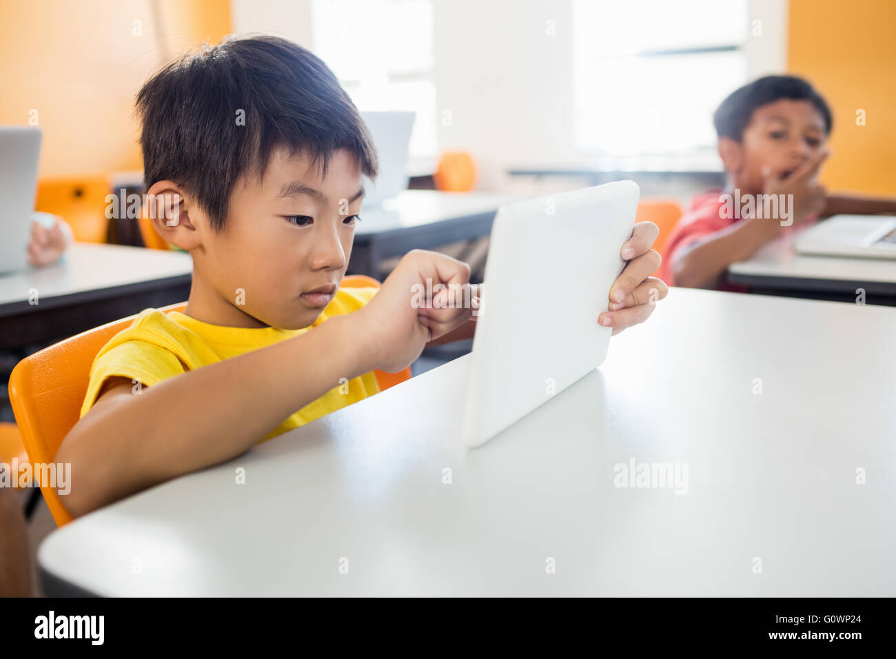 Little boy using tablet pc in classroom Stock Photo - Alamy