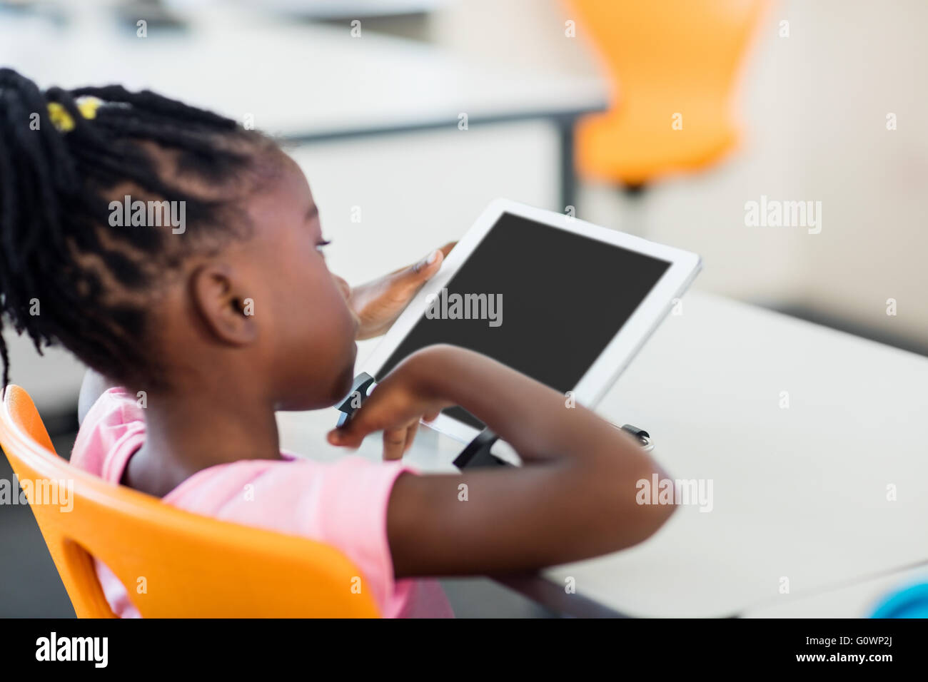 Side view of pupil using tablet pc in classroom Stock Photo - Alamy