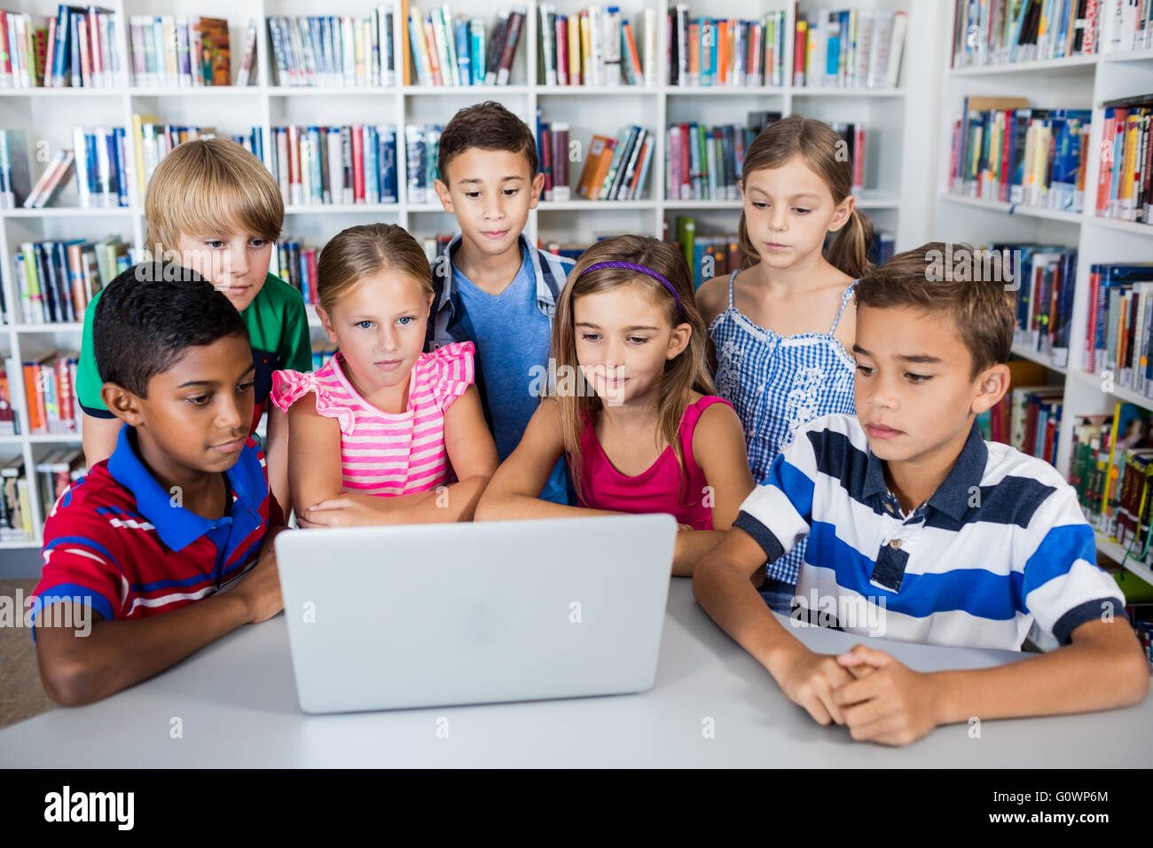 Cute pupils using laptop Stock Photo - Alamy