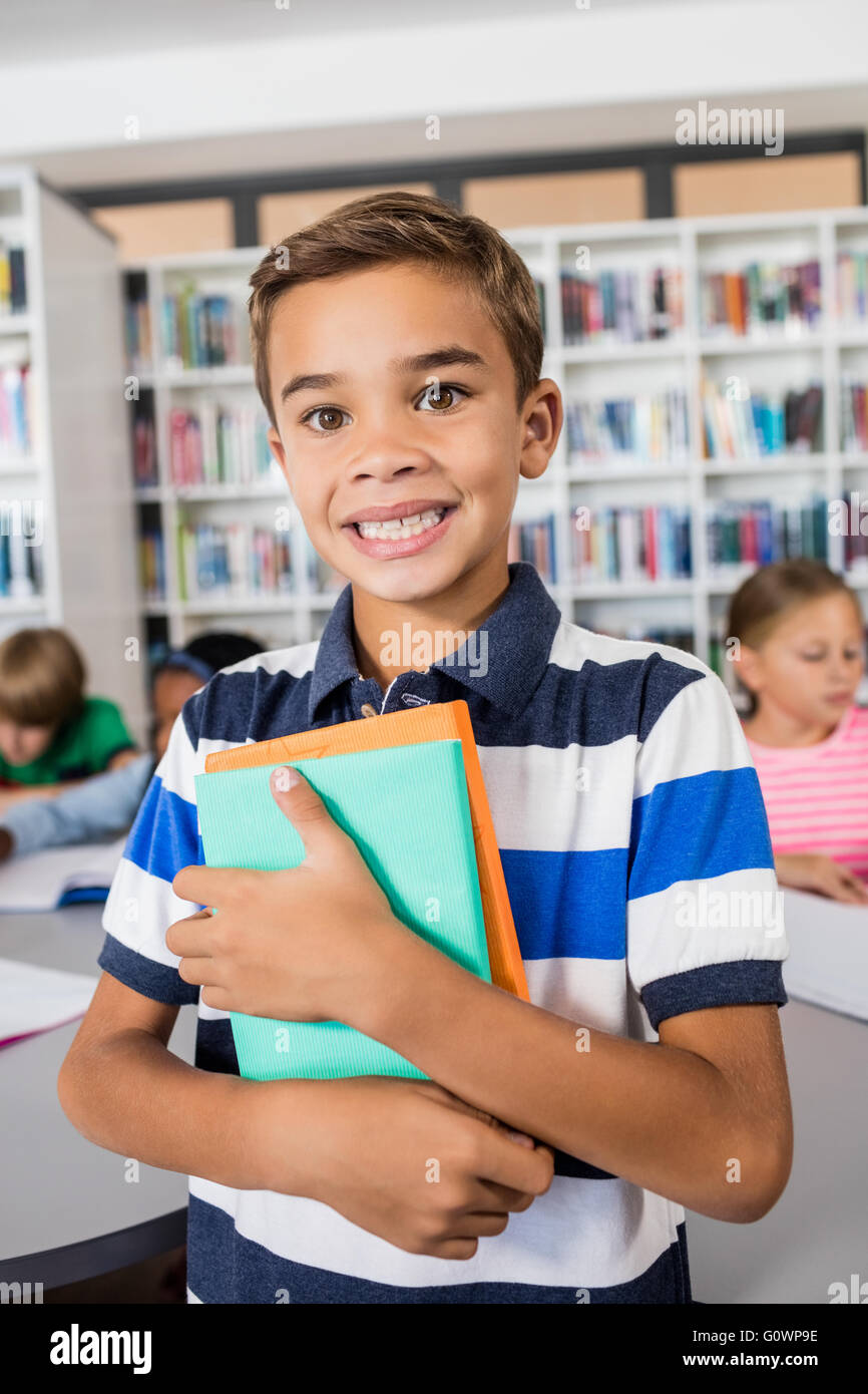 Little boy standing with notebooks Stock Photo - Alamy