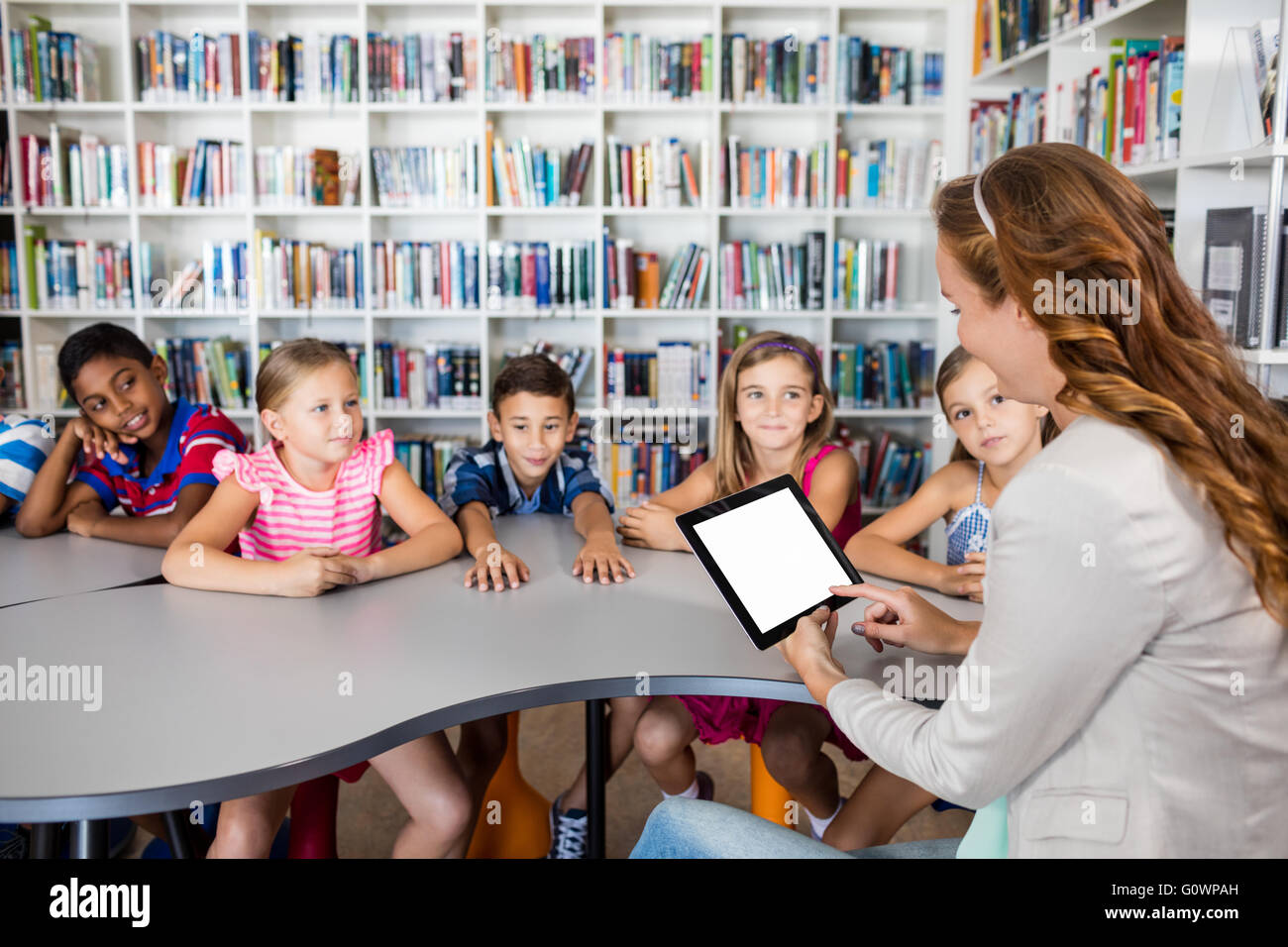 Teacher using tablet with pupils Stock Photo - Alamy