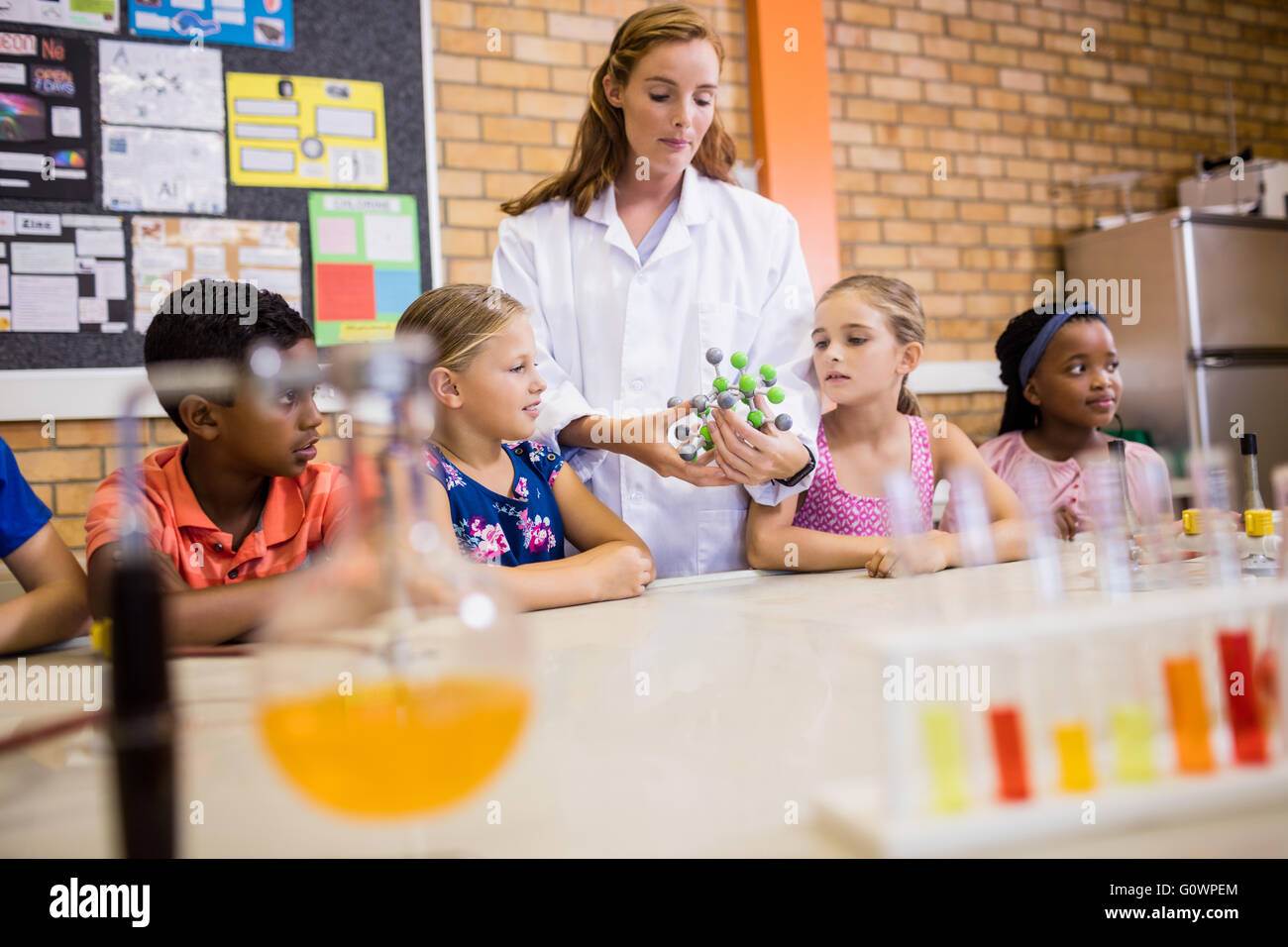 Teacher giving lesson to her students Stock Photo - Alamy