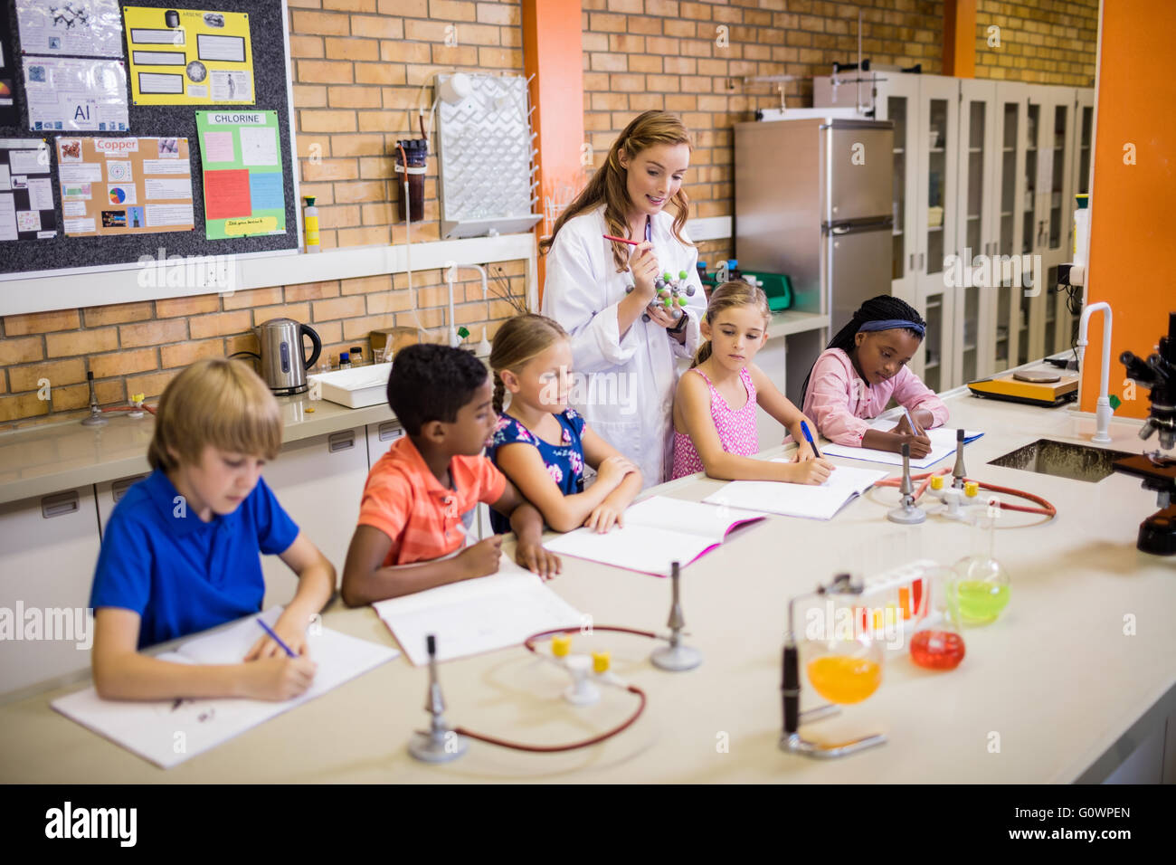 Teacher giving lesson to her students Stock Photo - Alamy