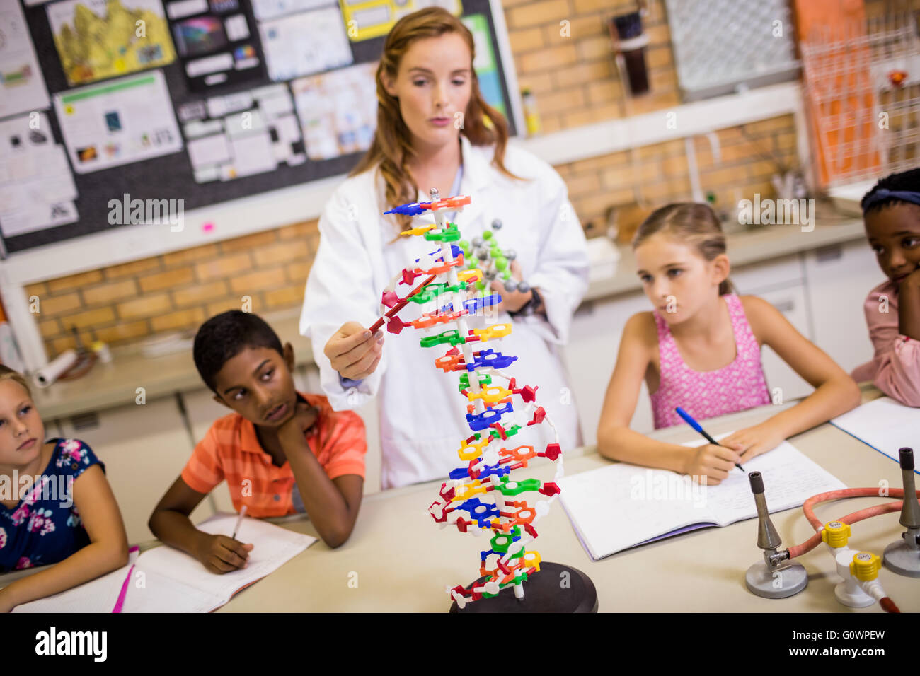 Teacher giving lesson to her students Stock Photo - Alamy