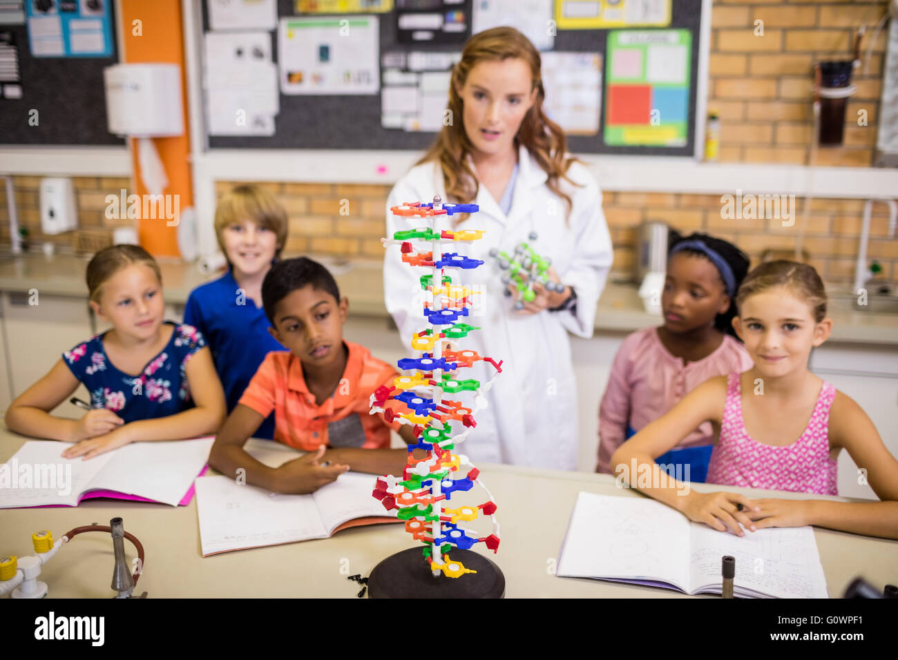 Teacher giving lesson to her students Stock Photo - Alamy