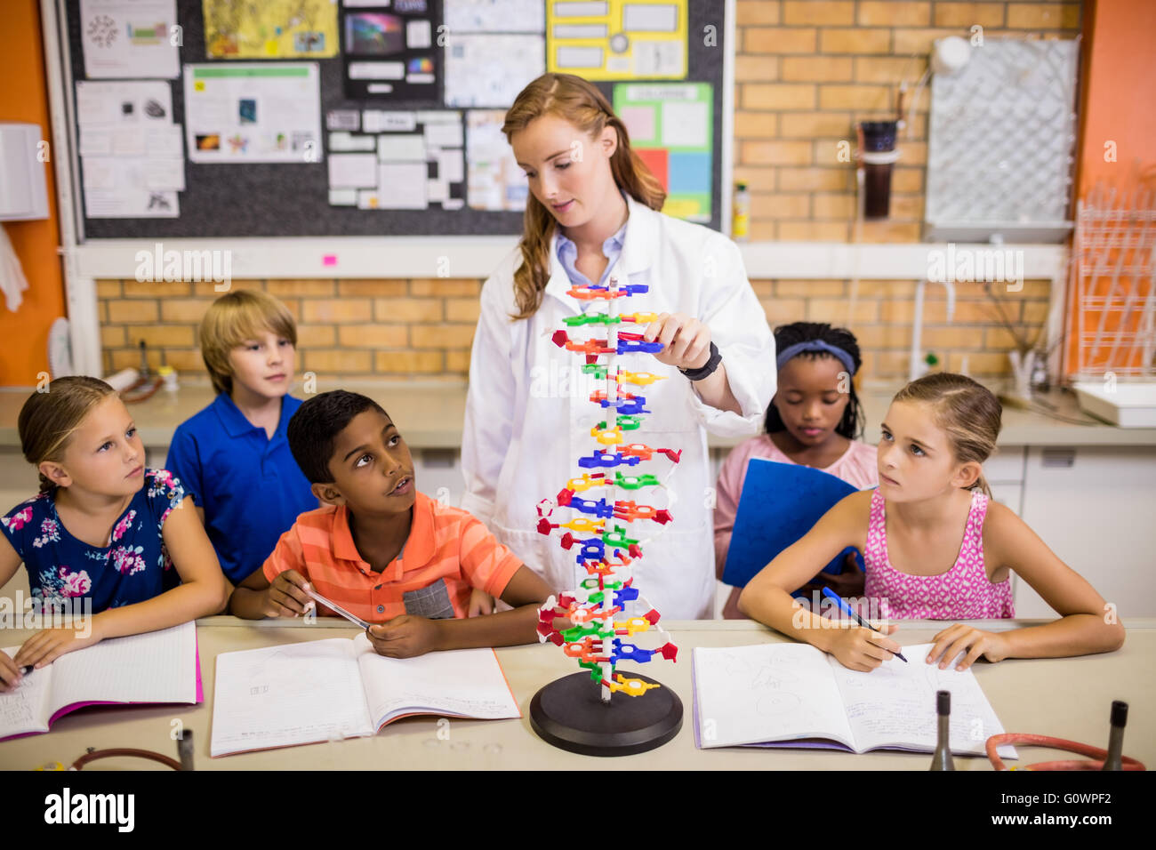 Teacher giving lesson to her students Stock Photo - Alamy