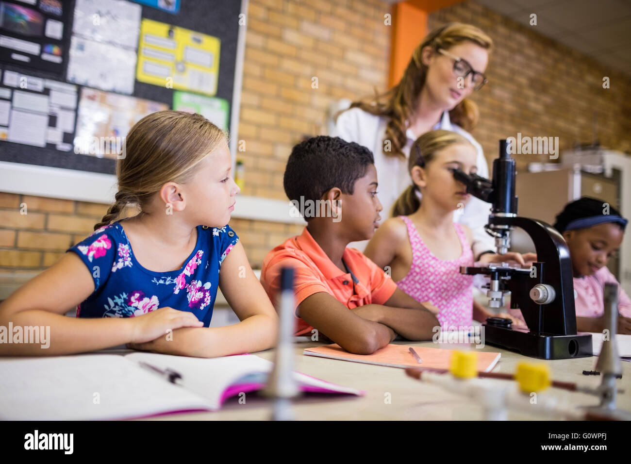 Teacher giving lesson to her students Stock Photo - Alamy