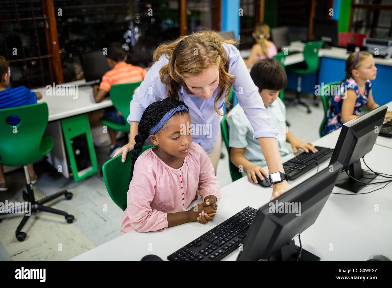 Teacher giving lesson to her students with technology Stock Photo - Alamy