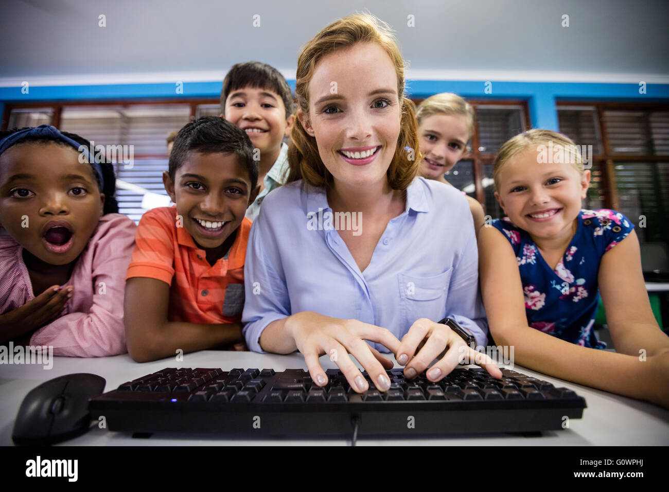 Teacher giving lesson to her students with technology Stock Photo - Alamy