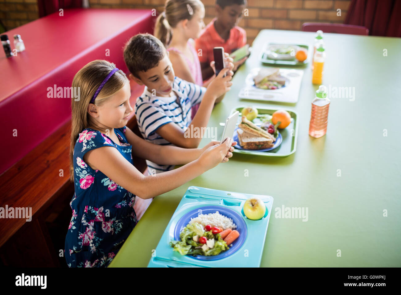 Children using technology during lunch Stock Photo - Alamy