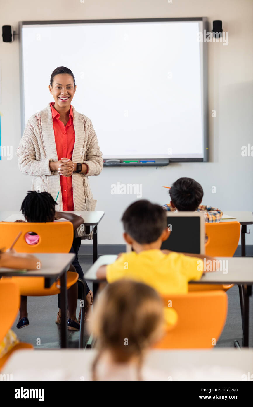 Teacher giving lesson to her students Stock Photo - Alamy