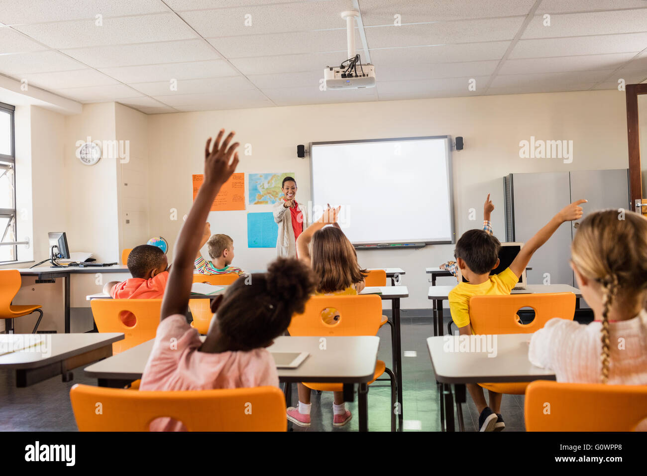 Teacher giving lesson to her students Stock Photo - Alamy