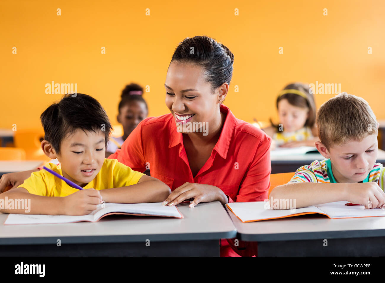 Teacher giving lesson to her students Stock Photo - Alamy