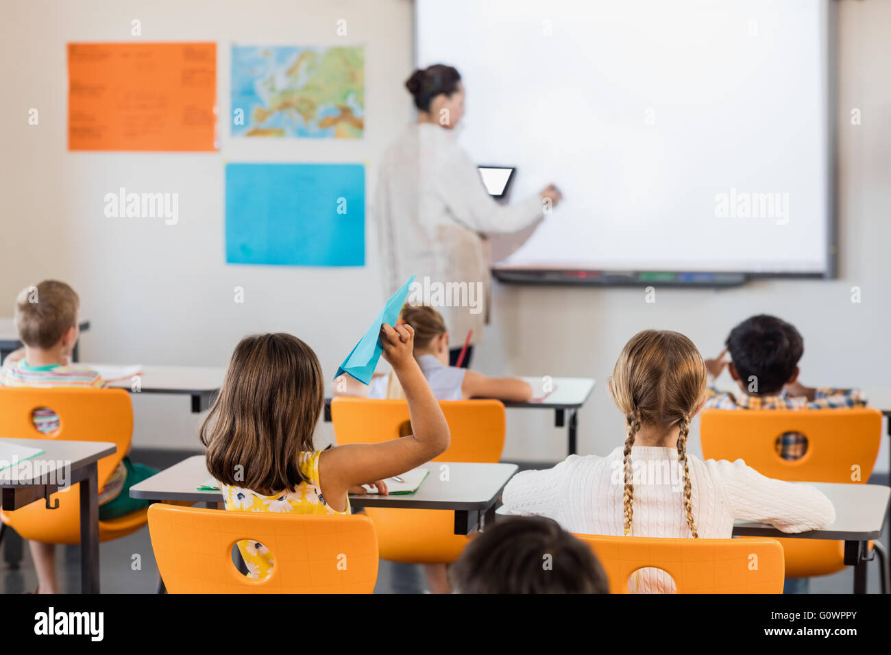 Teacher giving lesson to her students Stock Photo - Alamy