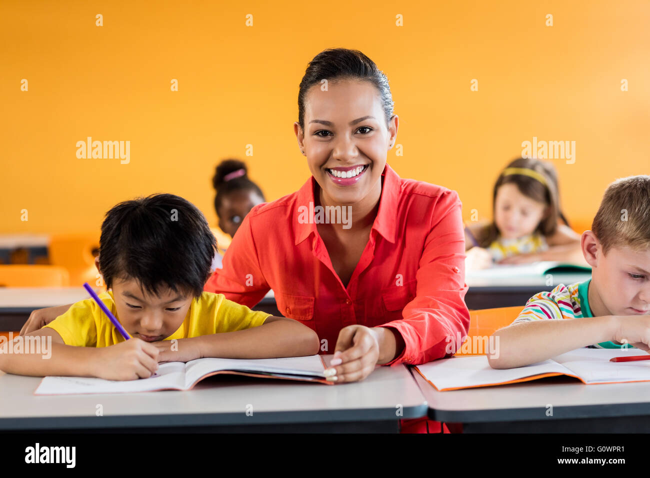 Teacher giving lesson to her students Stock Photo - Alamy