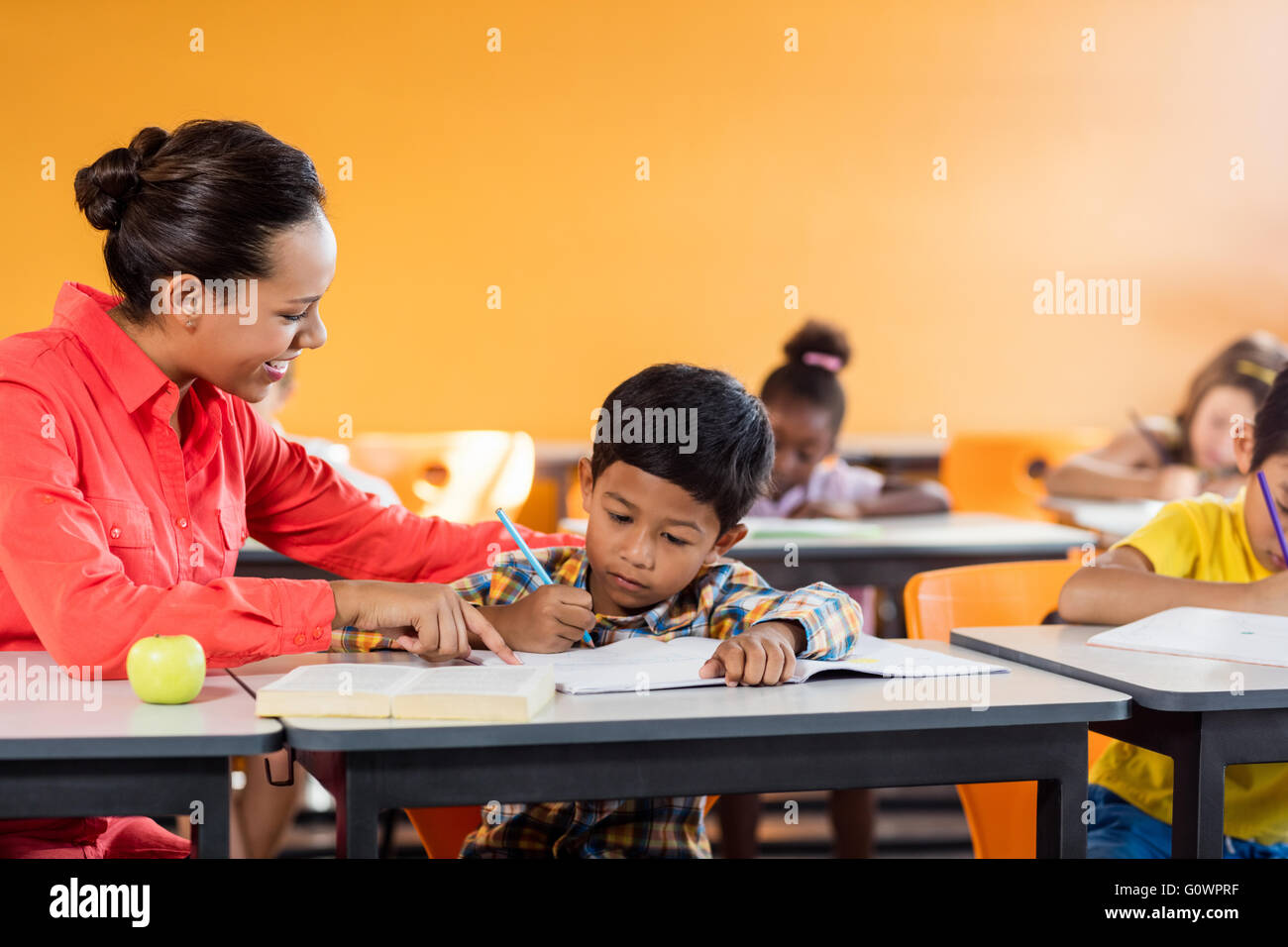 Teacher giving lesson to her students Stock Photo - Alamy