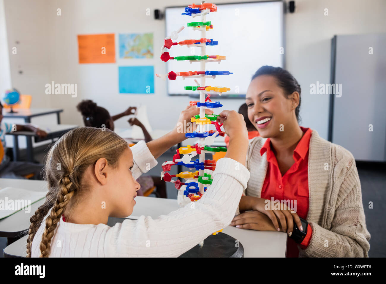 Teacher giving lesson to her students Stock Photo - Alamy