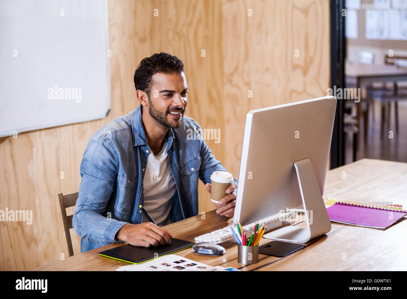 A young man writing notes at computer desk Stock Photo - Alamy