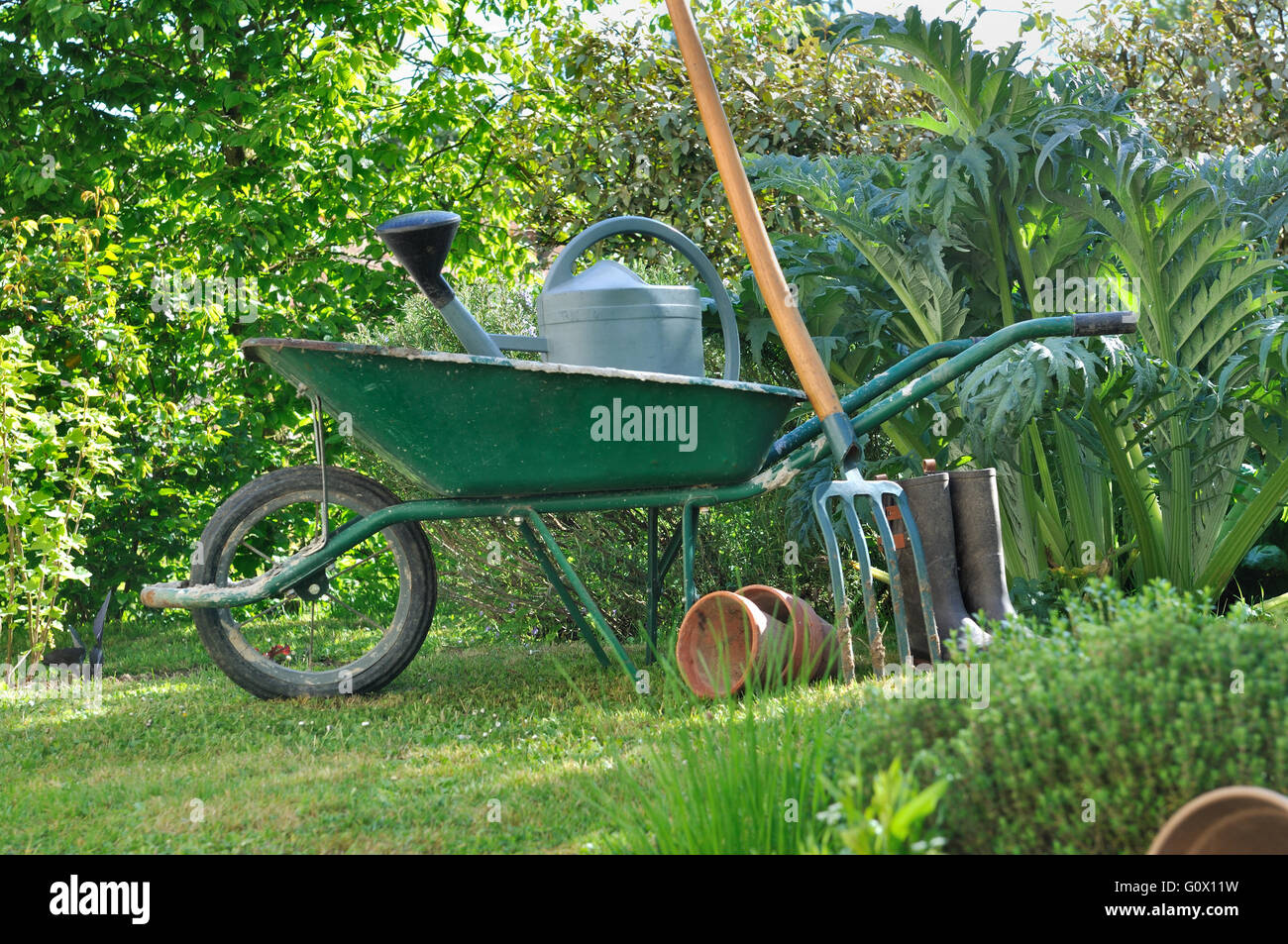 wheelbarrow and gardening tools Stock Photo - Alamy