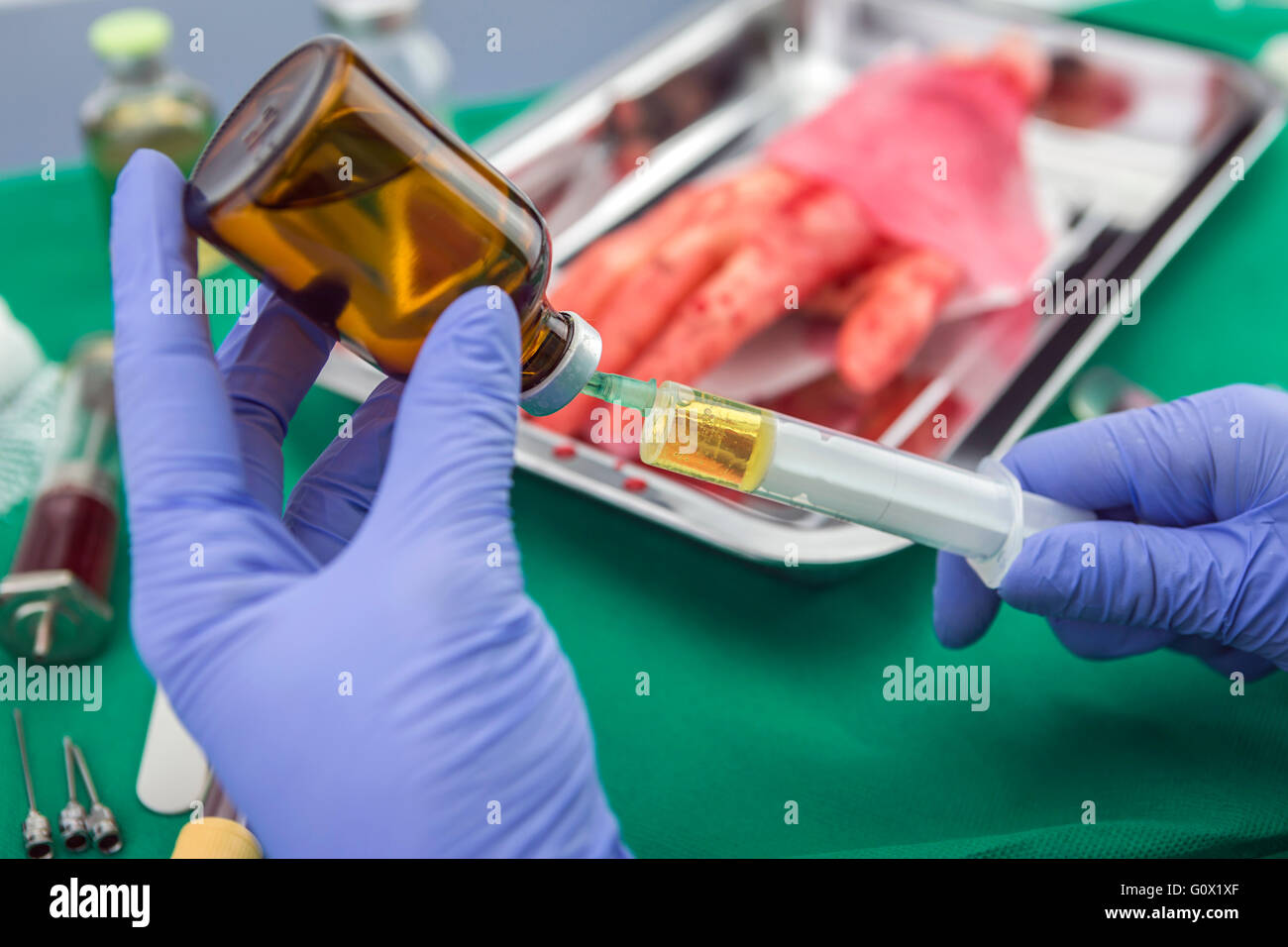 Nurse filling syringe with medication in a room of operating theater ...