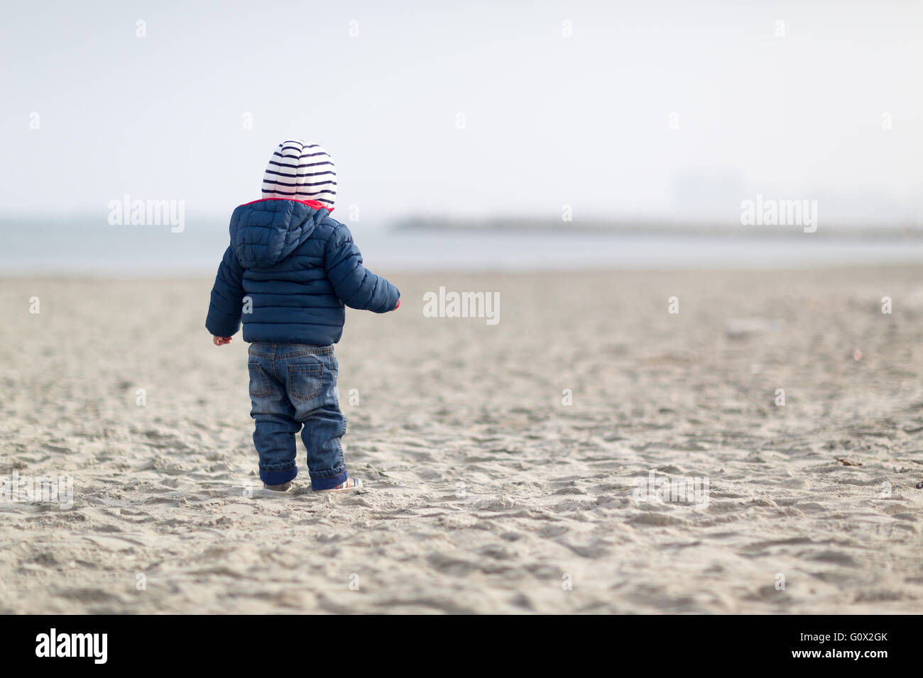 little boy standing on the beach. Eyes looking to the sea. Image from ...