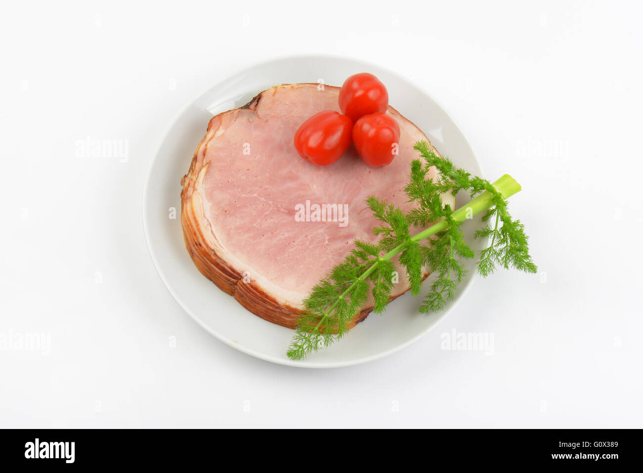 stack of ham slices, cherry tomatoes and dill on white plate Stock ...
