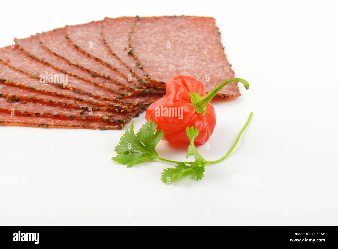 slices of pepperoni salami and spice on white background - close up ...