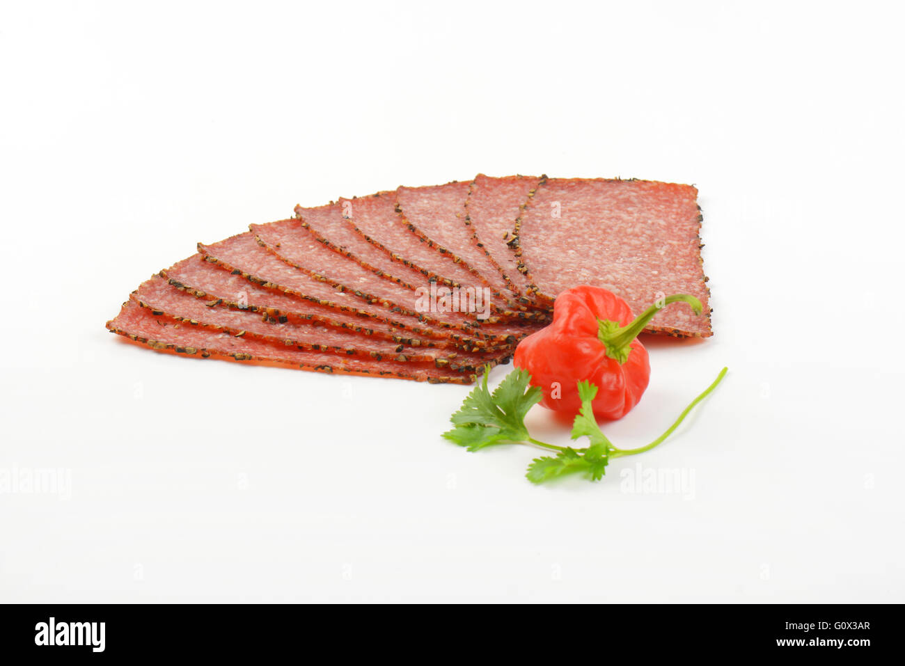 slices of pepperoni salami and spice on white background Stock Photo ...
