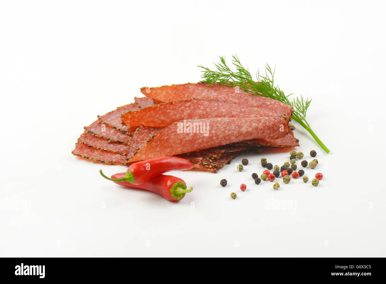 slices of pepperoni salami and spice on white background Stock Photo ...