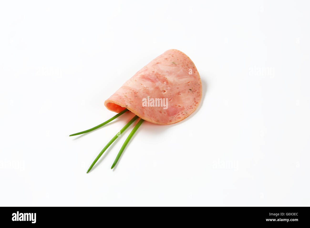 slice of ham salami with chives on white background Stock Photo - Alamy