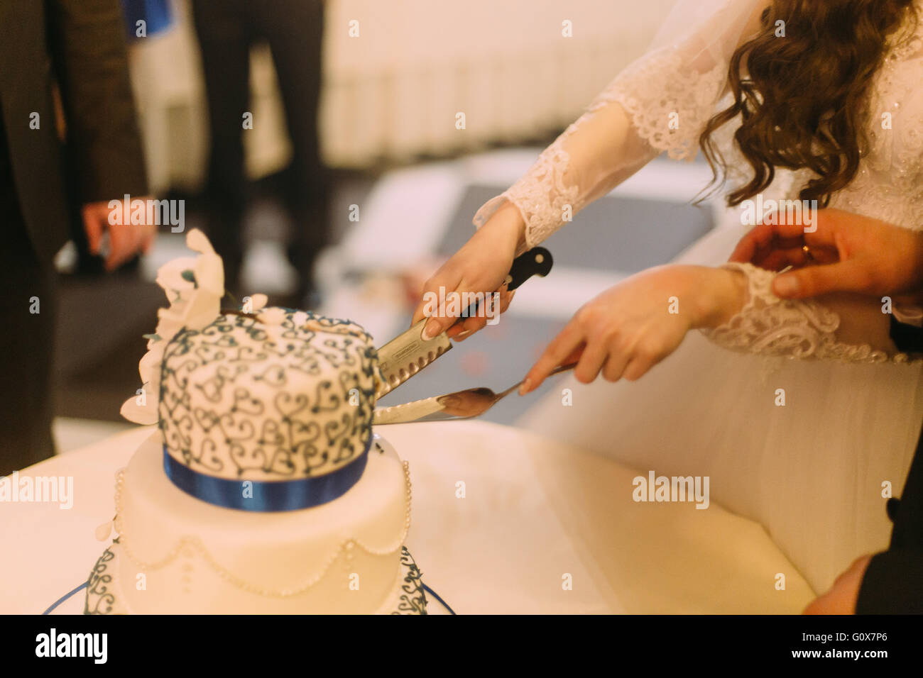 Beauty bride and handsome groom are cutting white wedding cake ...