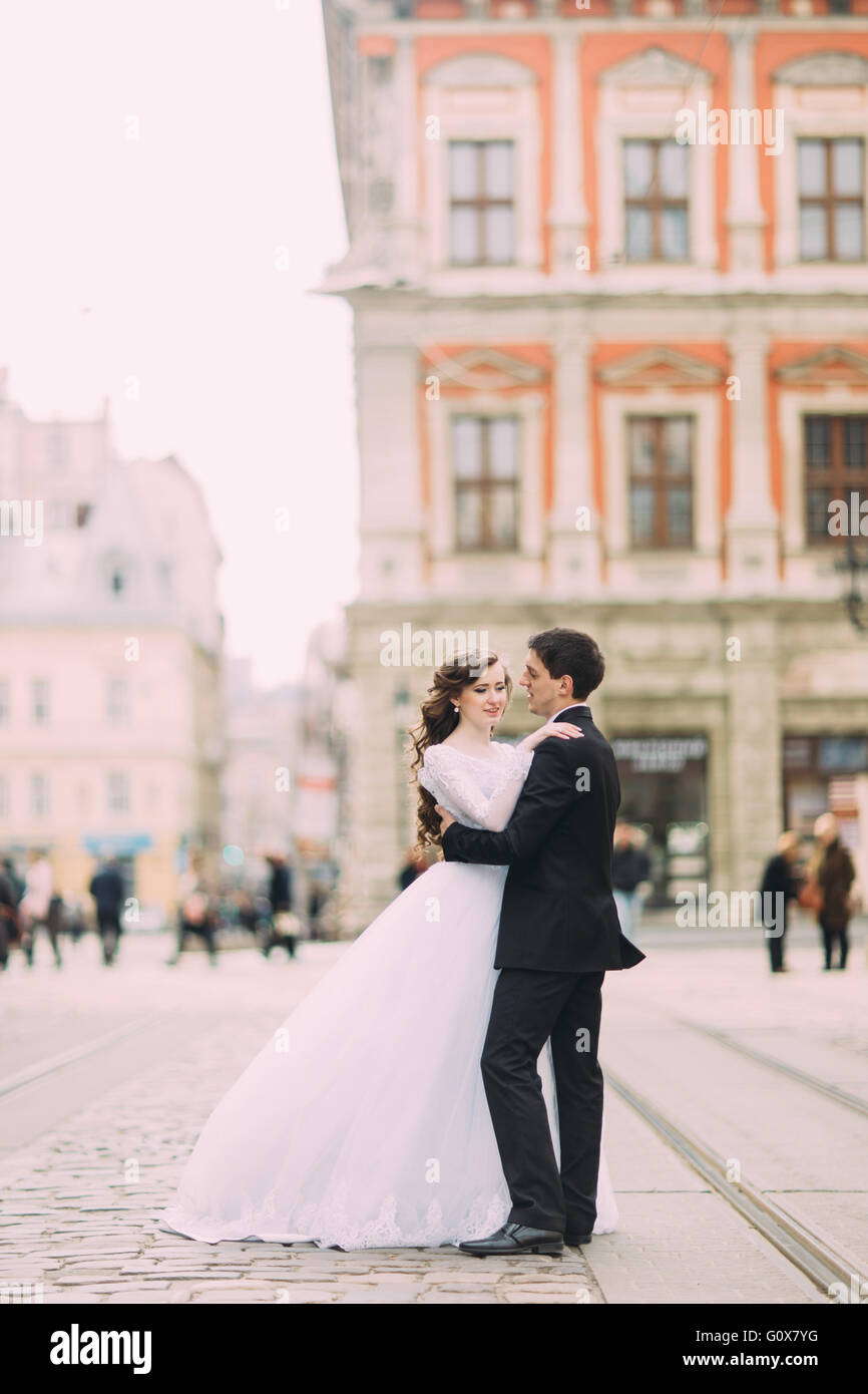 Happy bride and stylish groom running hugging on the background old ...