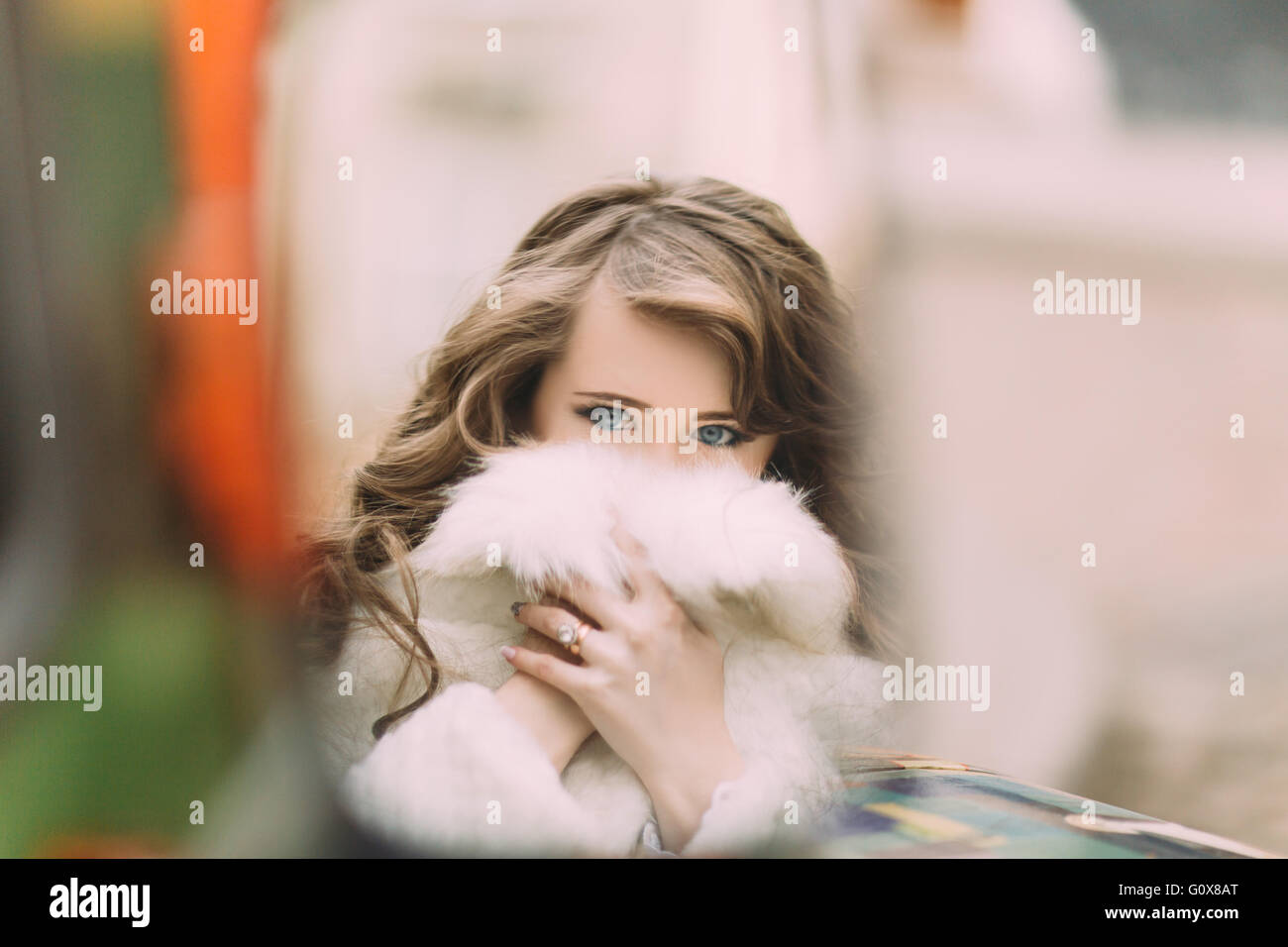 Reflection of pretty young woman closing their lips by fur cape in the ...