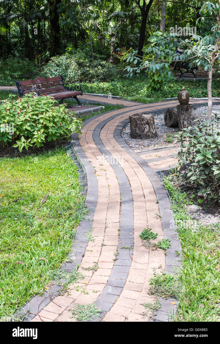 Block tile walkway with wooden bench in the urban park Stock Photo - Alamy
