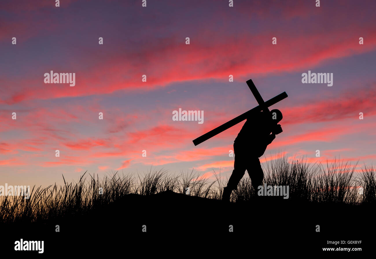Man with a carrying a cross on his back at sunrise Stock Photo - Alamy