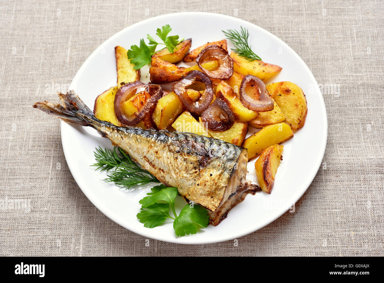 Fried mackerel fish and potato wedges on plate Stock Photo - Alamy