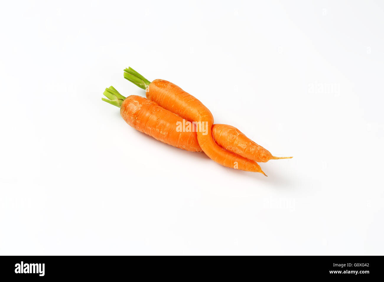two twisted carrots on white background Stock Photo - Alamy