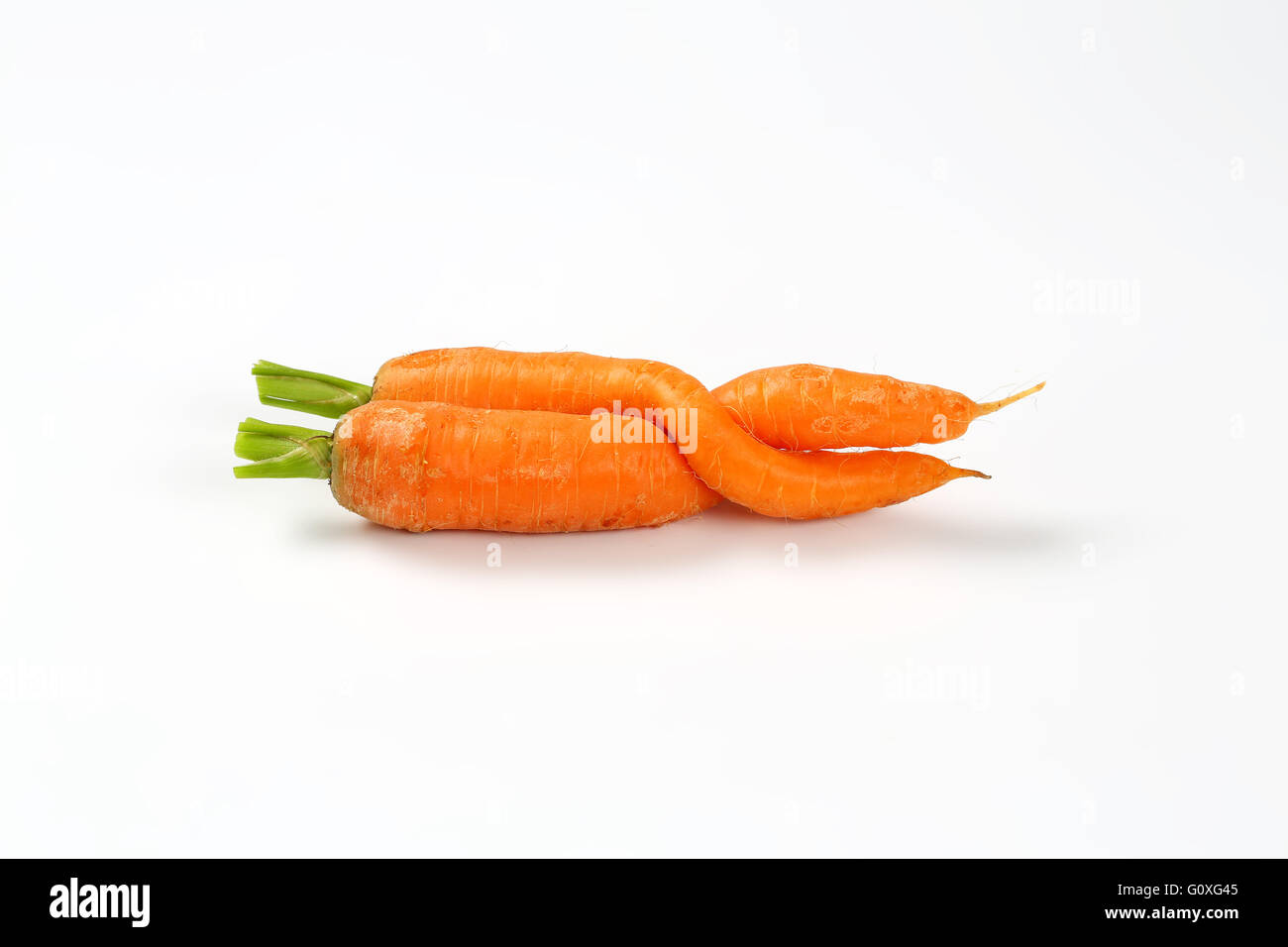 two twisted carrots on white background Stock Photo - Alamy