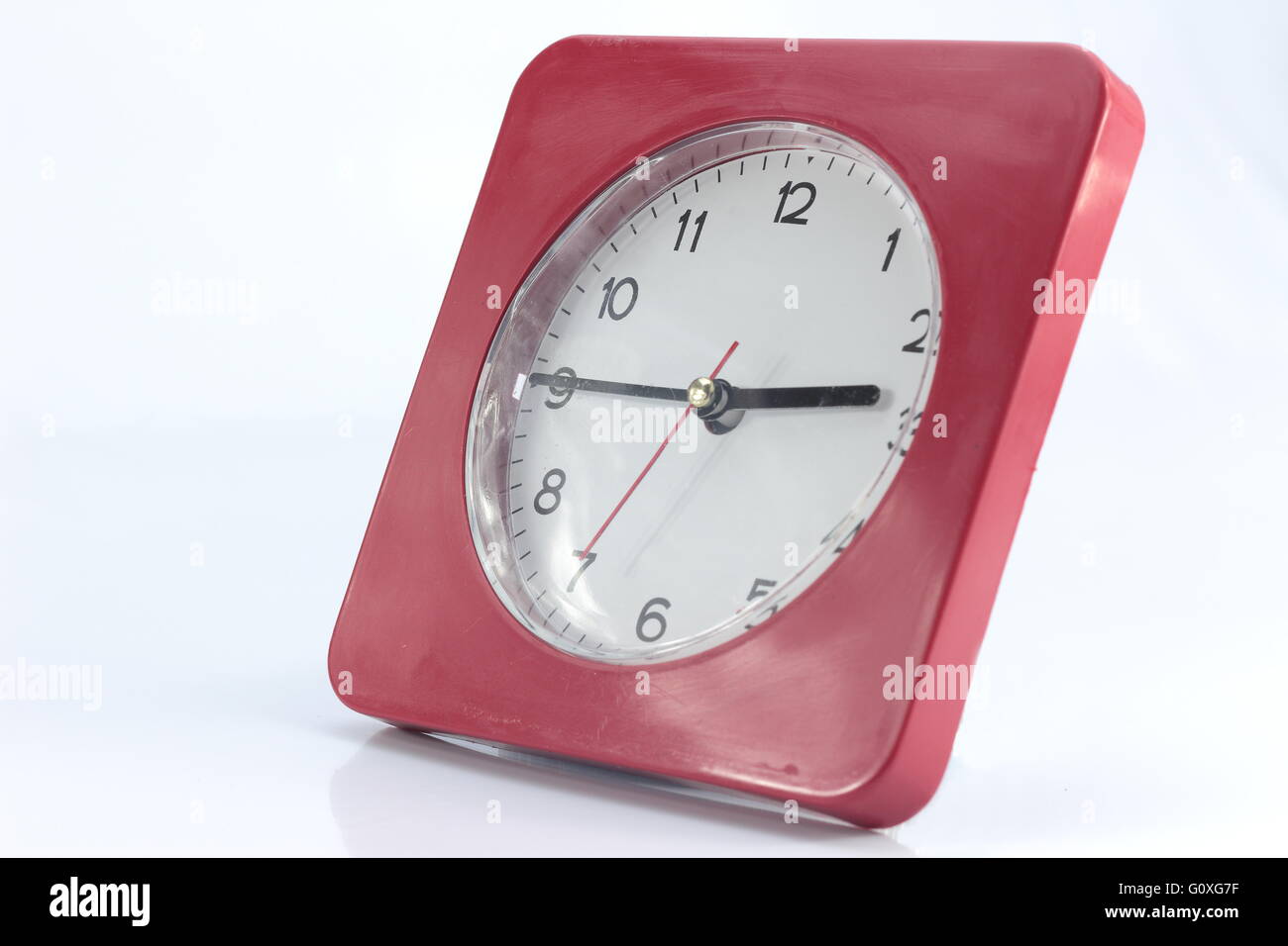 white and red wall small clock Stock Photo - Alamy