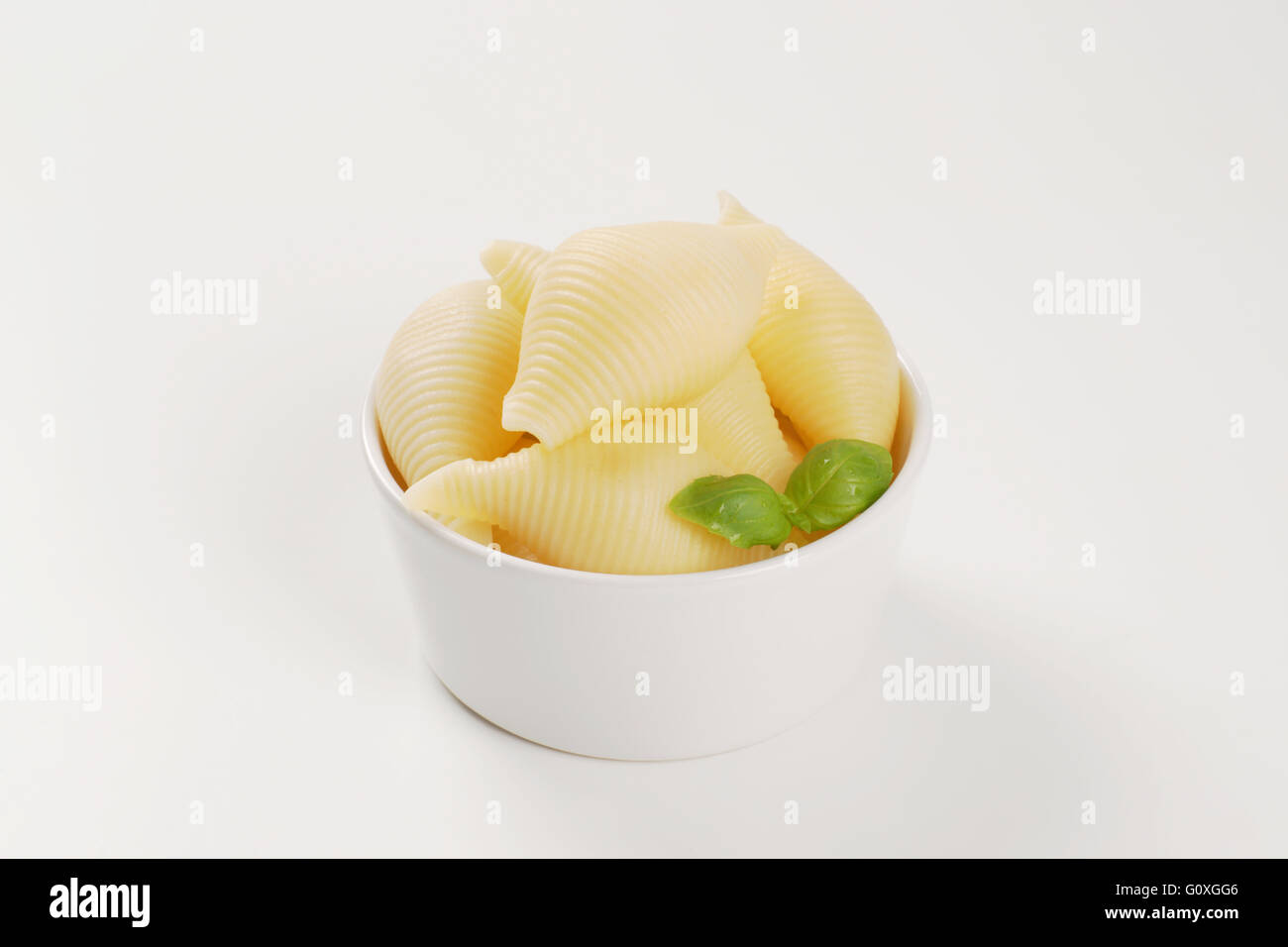 bowl of cooked pasta shells on white background Stock Photo - Alamy