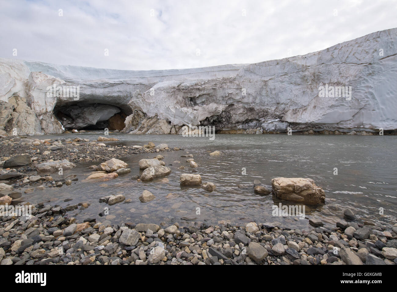 Low angle landscape view across a river to a snow bridge at Kalkstranda ...