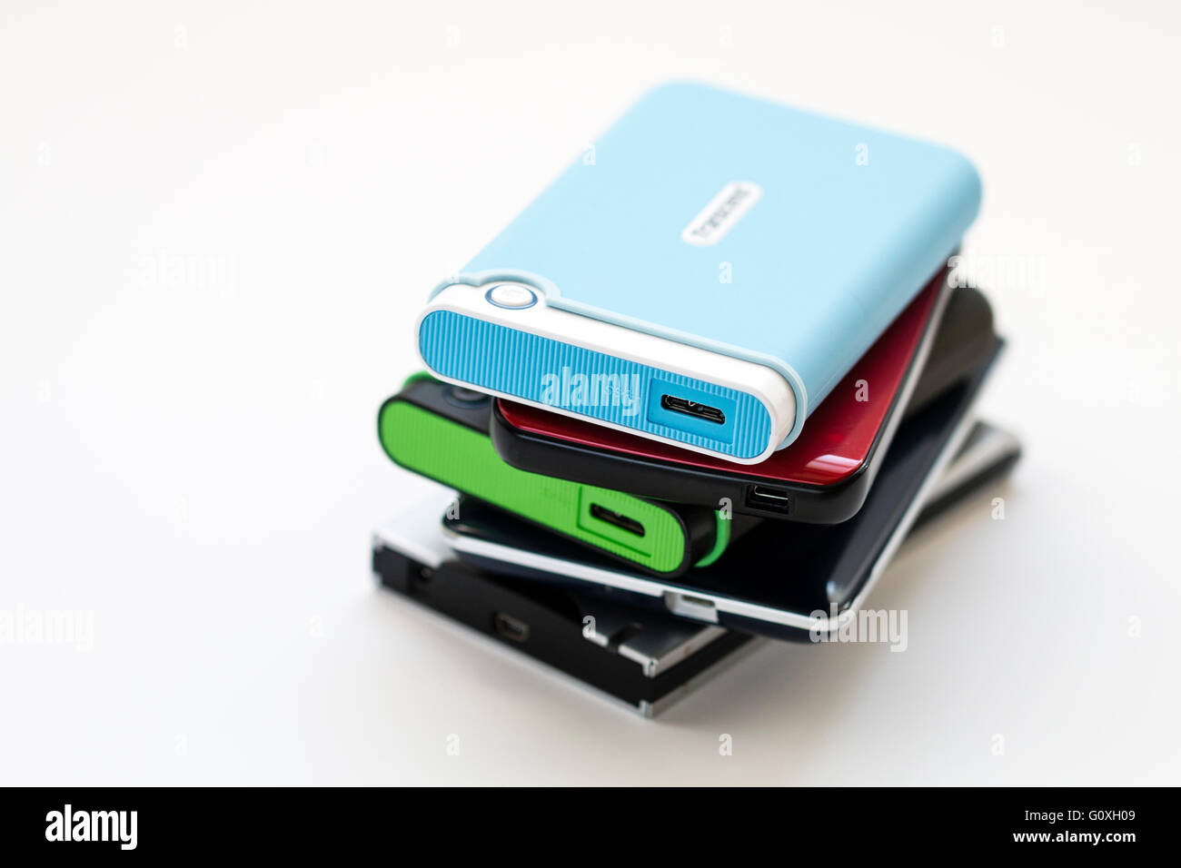 Stack of five different kinds and colours of portable hard drives. Top ...