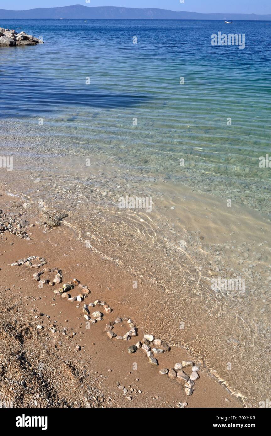 The Podgora word spelled out with pebbles on beach of Podgora. Croatia ...